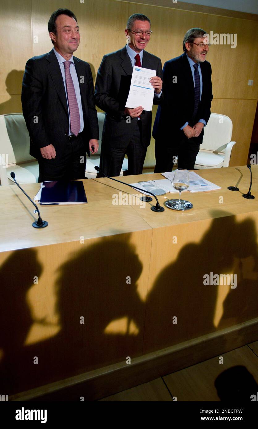 Spain's Mayor Alberto Ruiz-Gallardon, center, holds up a signed ...
