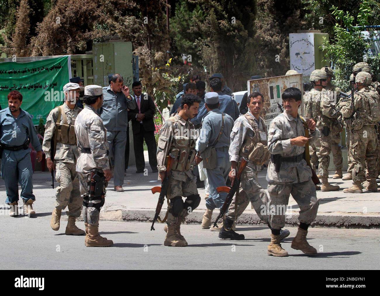 Afghan border police men, in camouflage uniform, walk past the gate of ...