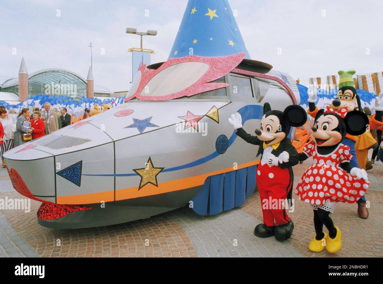 Mickey Mouse, Minnie and Pluto pose next to a replica of a high-speed ...