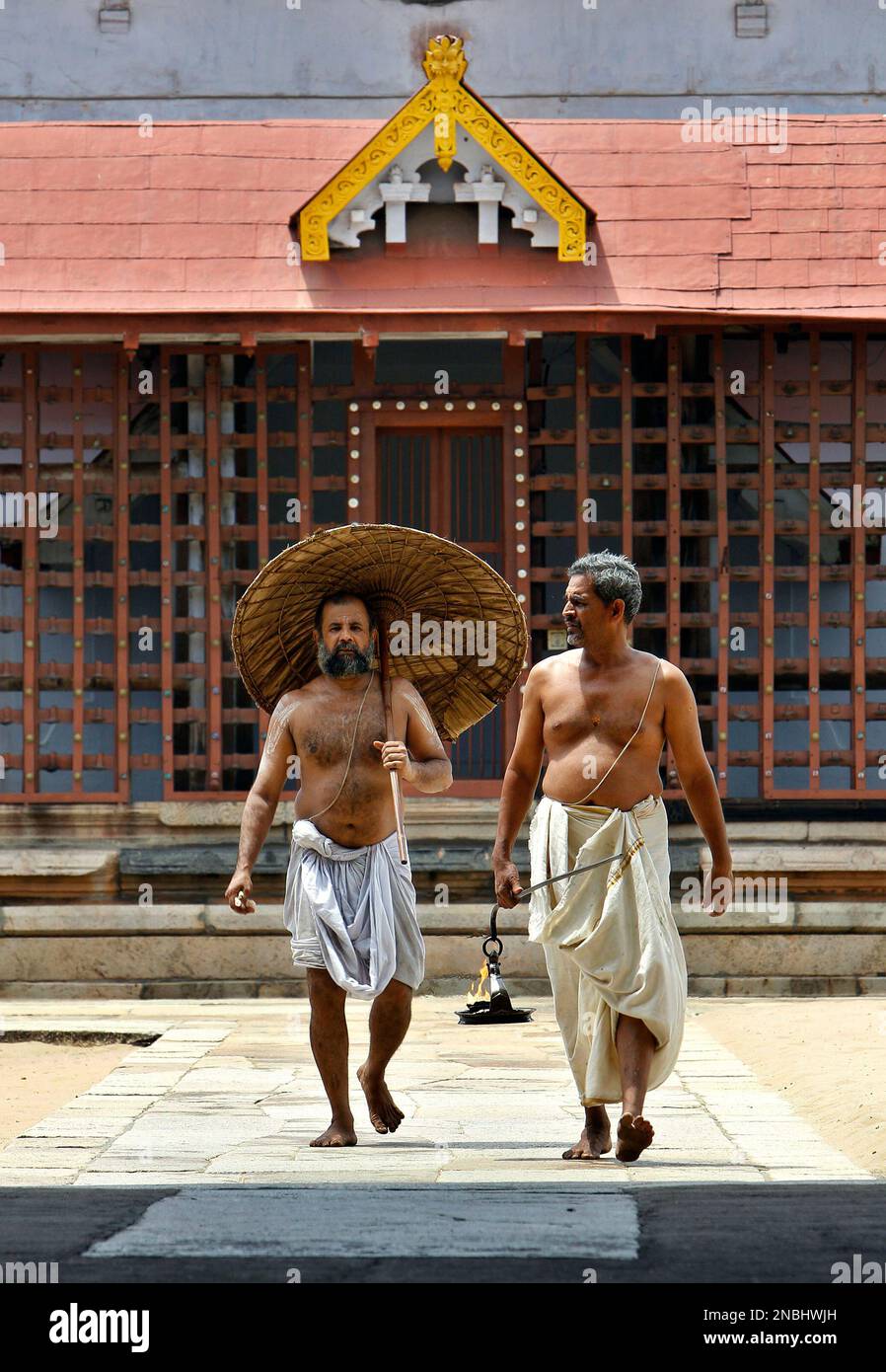 Hindu priests walk in front of a building housing the vaults at the ...