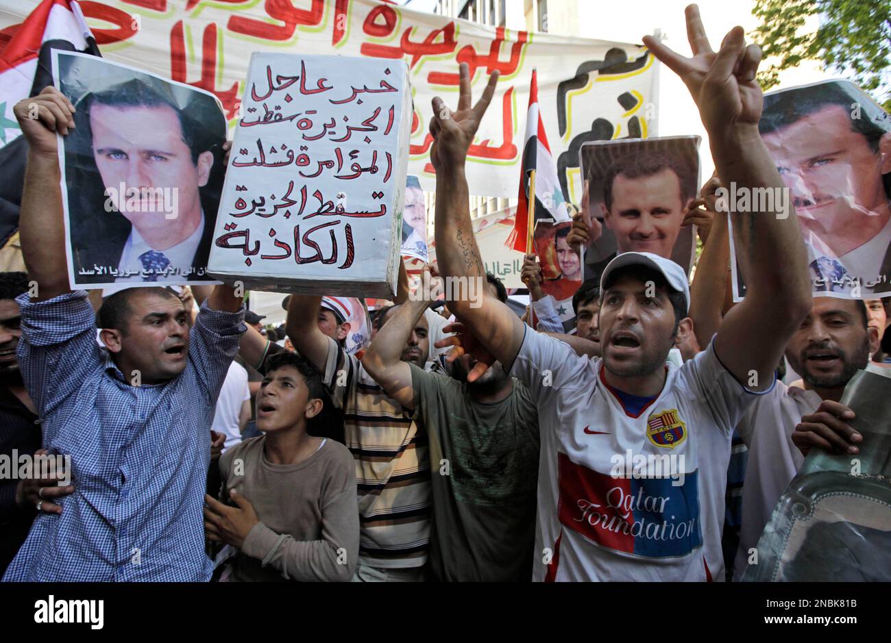 Lebanese and Syrian protesters shout slogans as they carry pictures of ...
