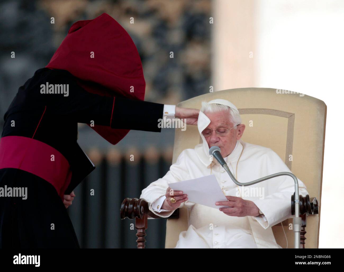 Archbishop James Harvey's mantle is blown by the wind as he tries to ...