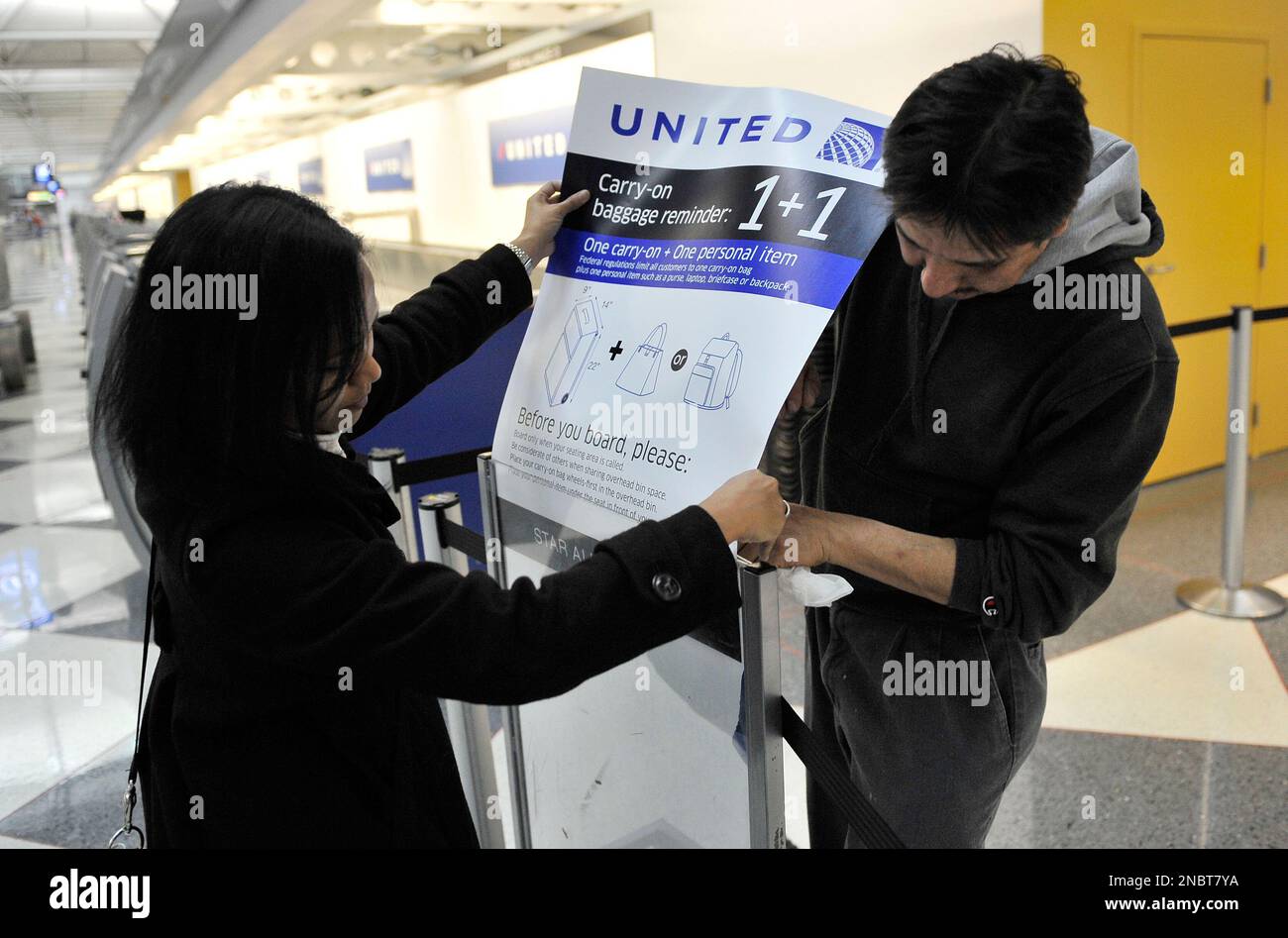 Tricia Johnson, left, and Luis Gonzalez put up a new sign with the new ...