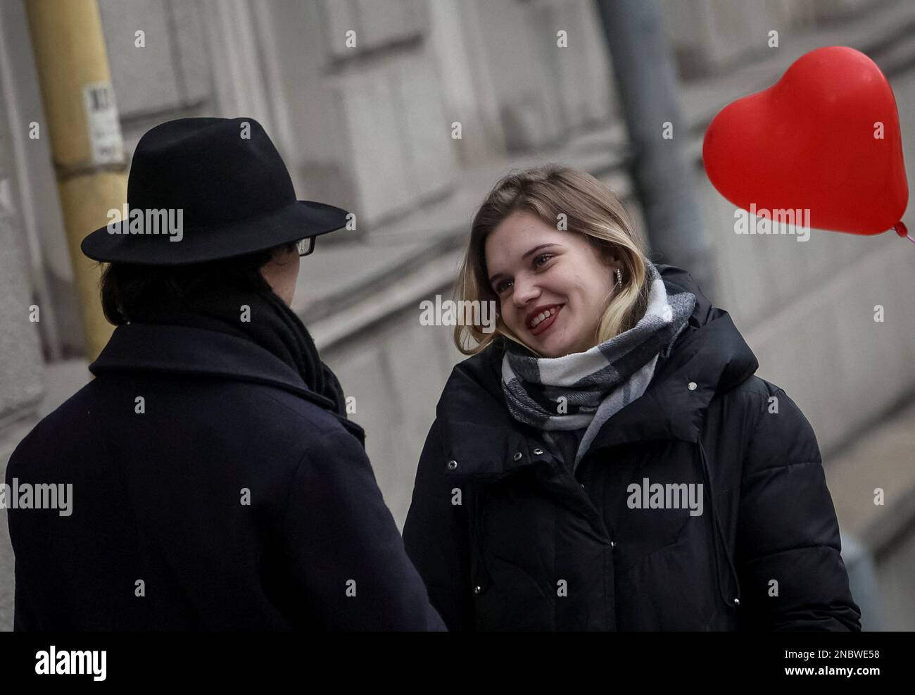 Eine Frau spricht auf der Straße, während ein Ballon am Valentinstag in der Nähe, inmitten ...