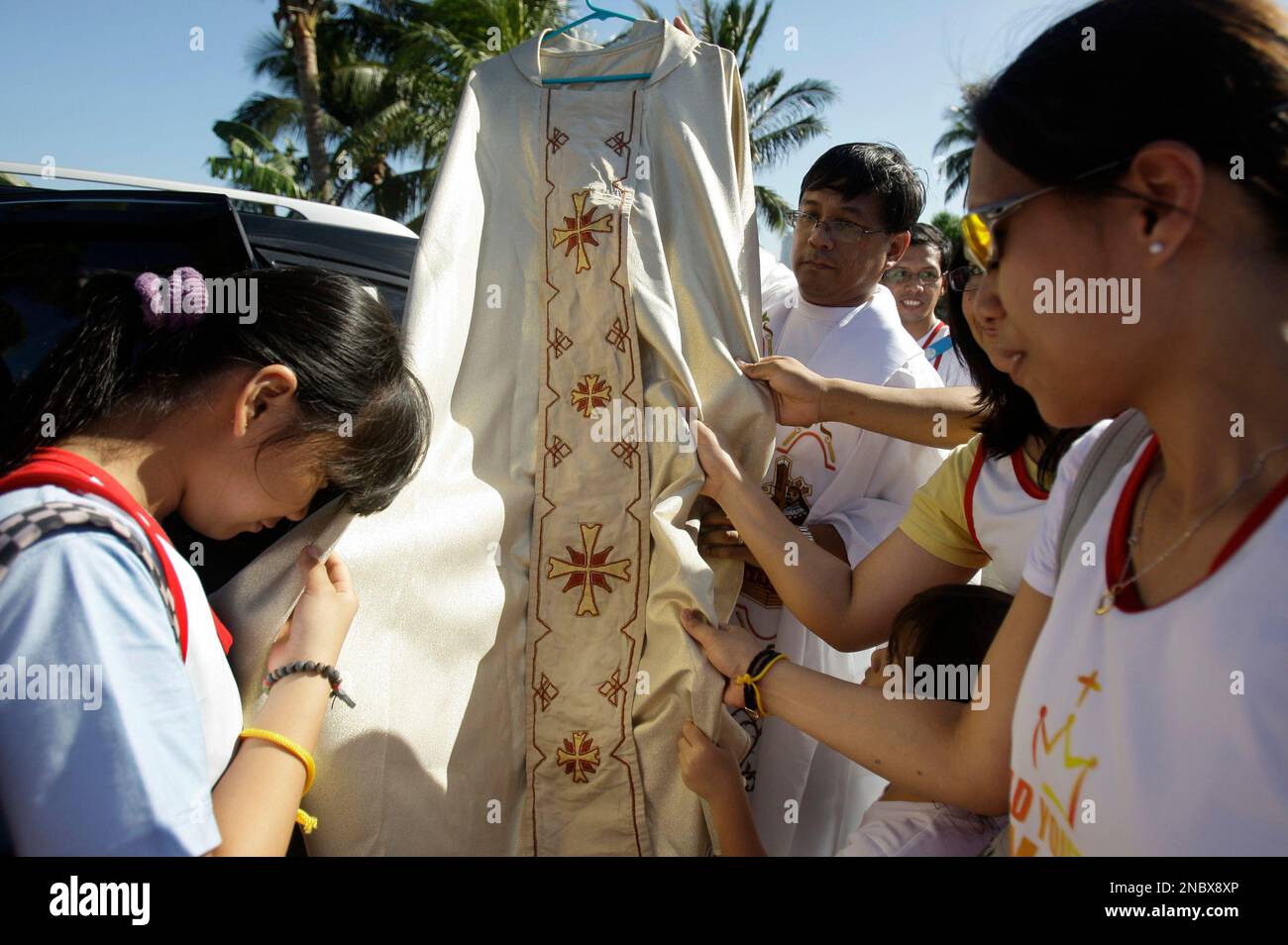 Filipino devotees touch a religious cloak which Pope John Paul II wore ...
