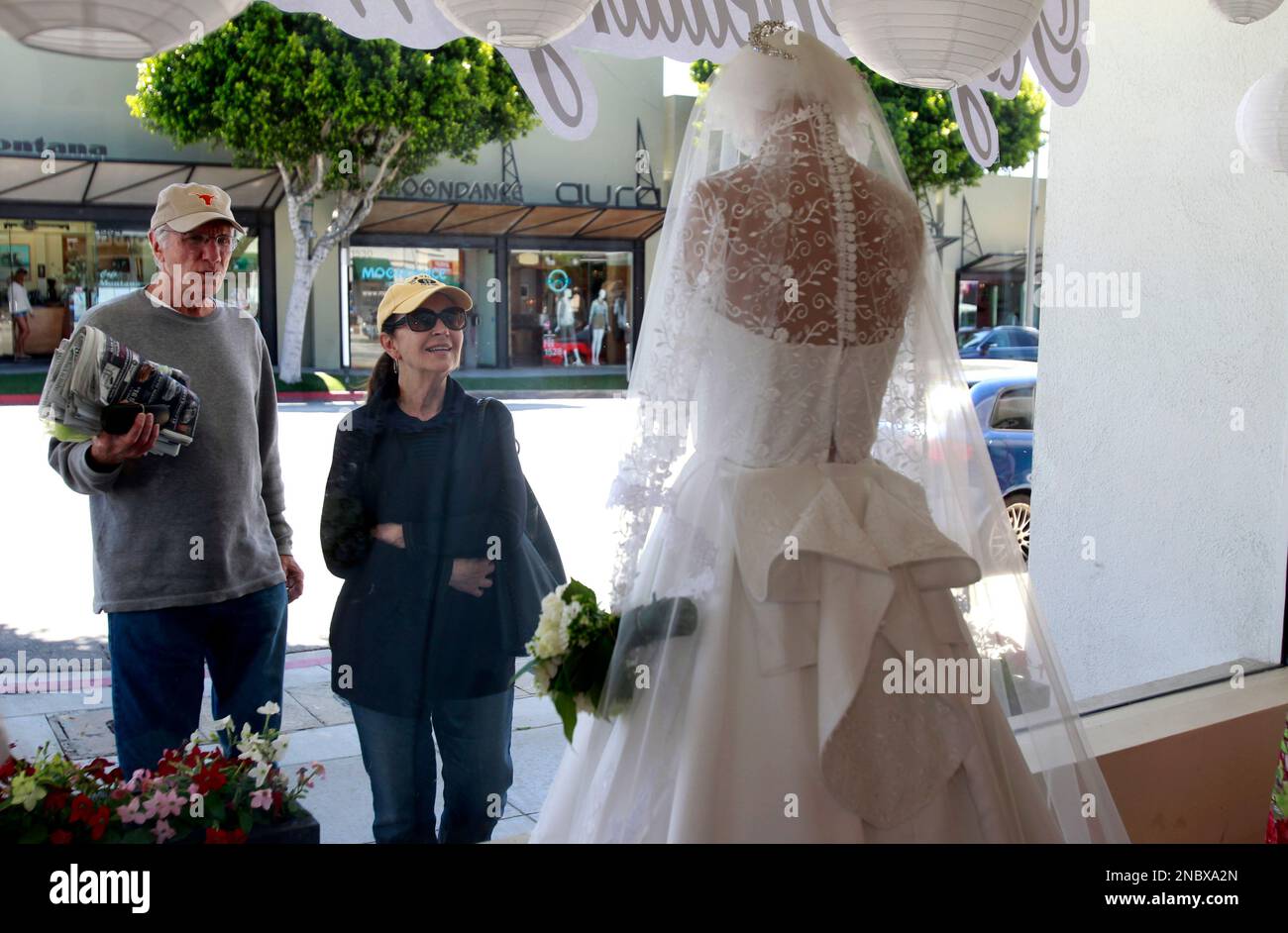 Spectators look at a knockoff design of the royal wedding gown worn by ...