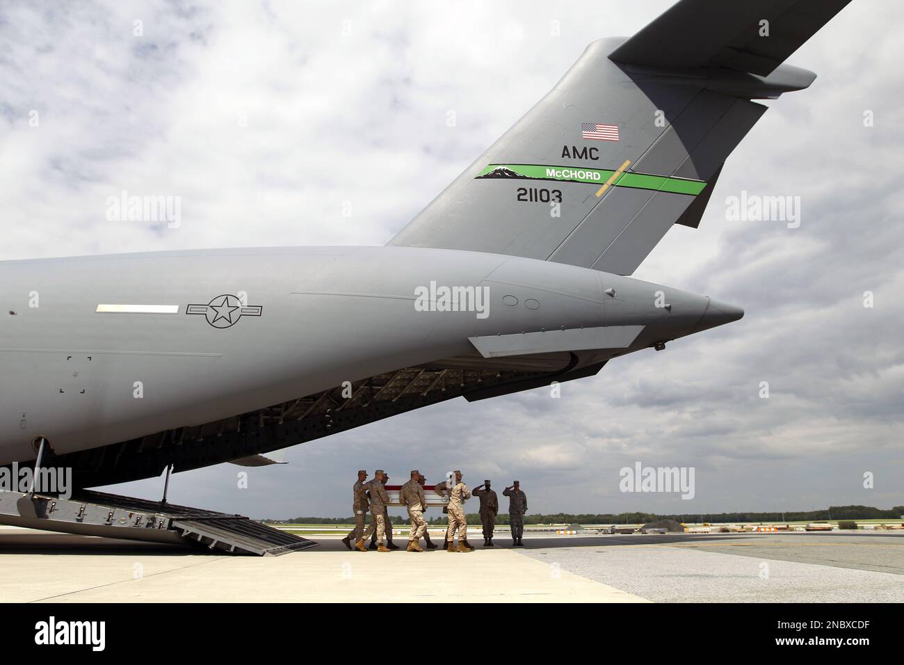A Marine carry team carries the transfer case containing the remains of ...