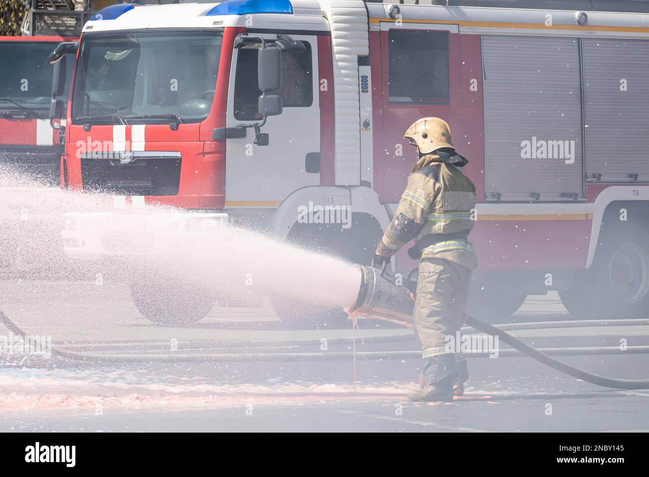 Feuerwehrleute löschen ein Feuer aus einem Löschfahrzeug. Starker ... Feuerwehrleute löschen ein Feuer aus einem Löschfahrzeug. Starker ...