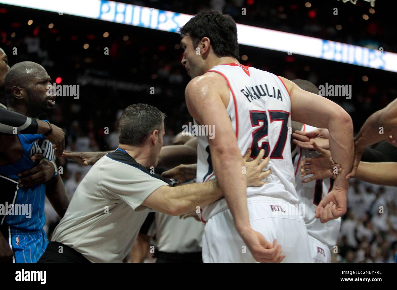 An officia, center,l steps between Atlanta Hawks center Zaza Pachulia ...