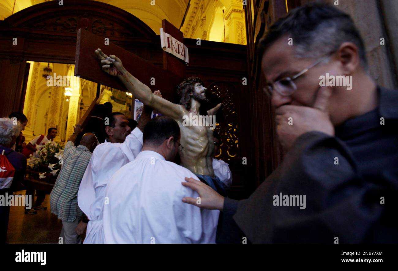 A priest, right, gestures as seminarians carry an image of Jesus Christ ...