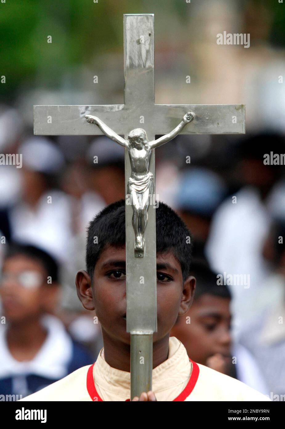 A Sri Lankan Roman Catholic boy carries a cross depicting the ...