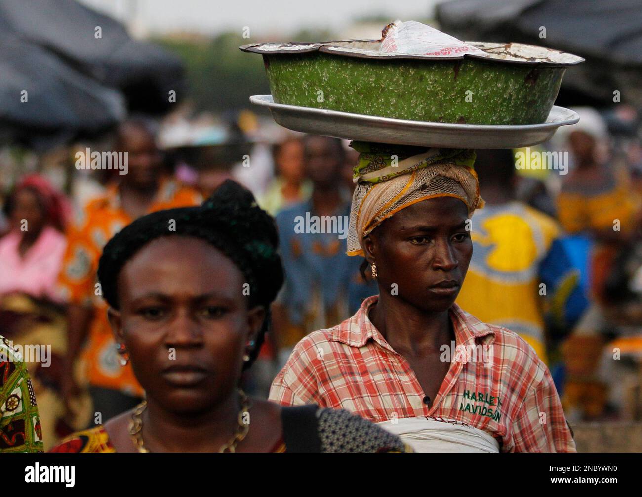 Women walk through a market in the Abobo neighborhood of Abidjan, Ivory ...