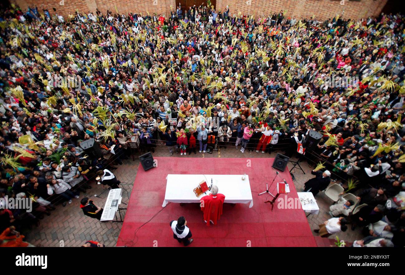 The faithful hold their palm fronds during a Palm Sunday Mass at El ...