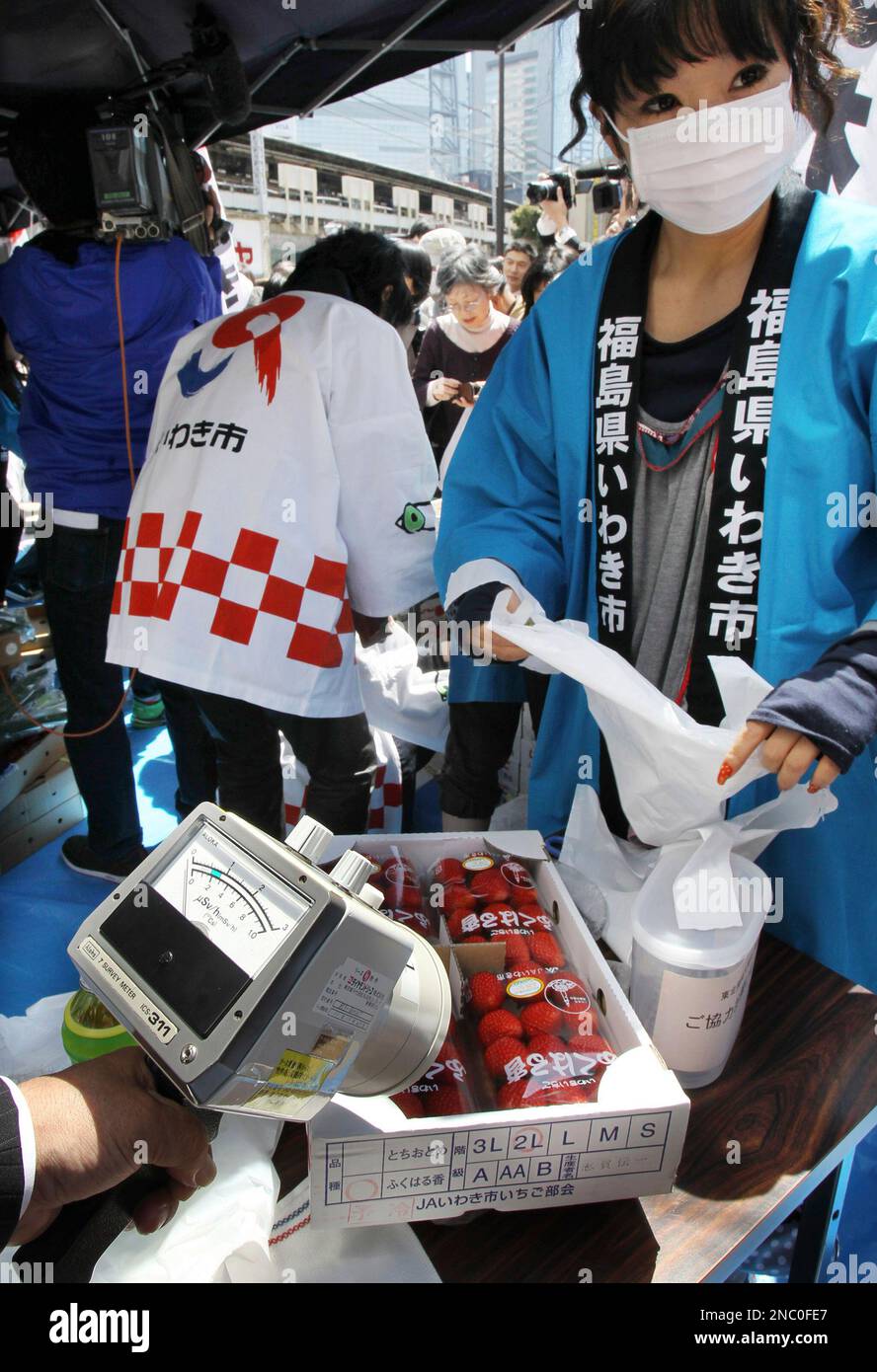 A man uses a radiation detector to measure level of a pack of ...