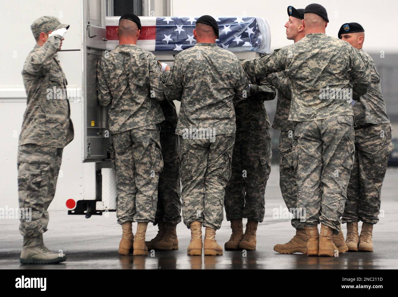 An Army carry team moves a transfer case containing the remains of ...