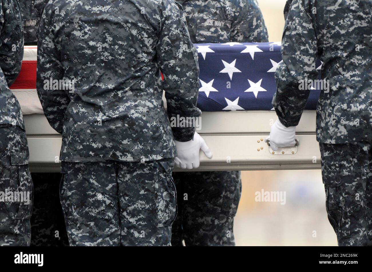 A Navy carry team moves a transfer case containing the remains of Petty ...