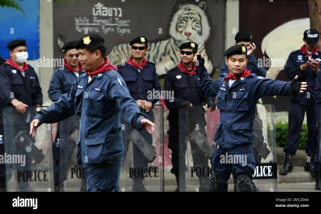 Thai riot police officers guide the traffic at a checkpoint set up to ...