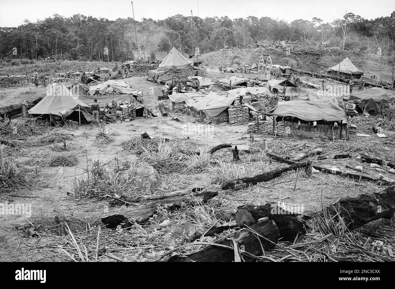 Sandbagged bunkers, topped with canvas, are living quarters of units of ...