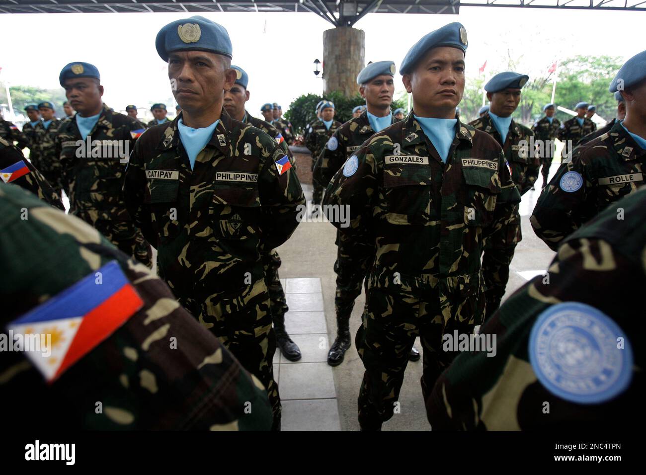 Filipino troopers stand at attention during a send-off ceremony for the ...