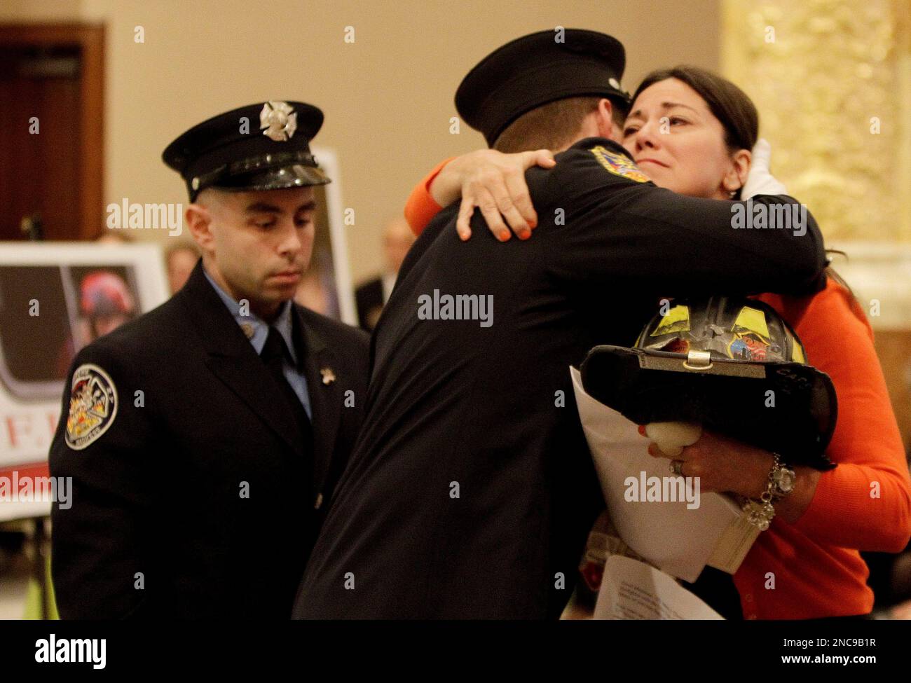 Firefighters from Ladder Co. 24 and Engine Co. 1 embrace Gretchen Witt ...