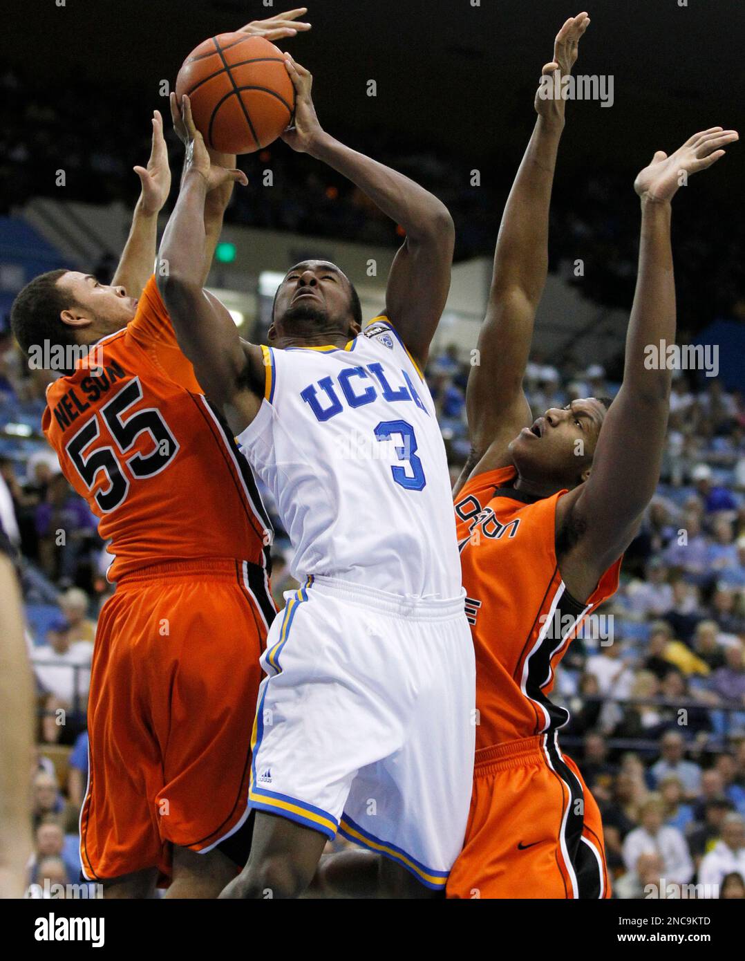 UCLA's Malcolm Lee, center, is fouled by Oregon State's Chris Brown ...