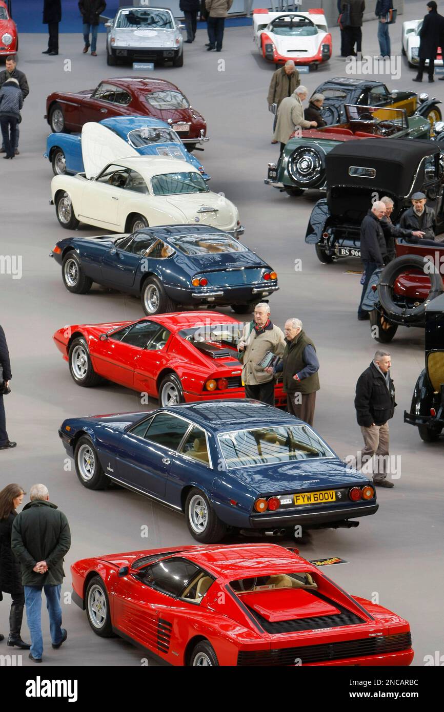 Visitors walk past vintage and classic cars displayed by Bonhams ...