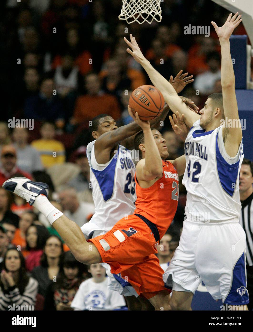 Syracuse's Brandon Triche (20) takes a shot between Seton Hall's Fuquan ...