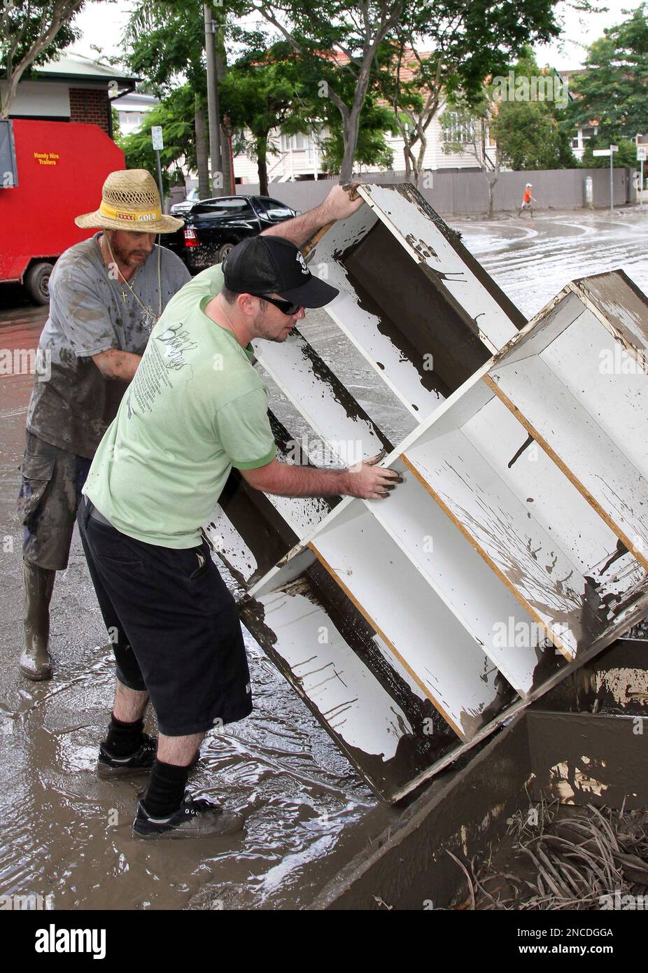 Unidentified residents in New Farm clear away debris from their flooded ...