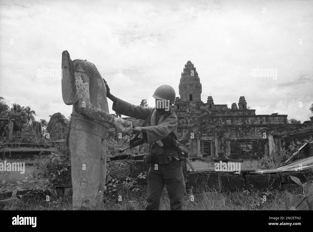 Cambodian government soldier looks over a 1,000-year old statue on the ...