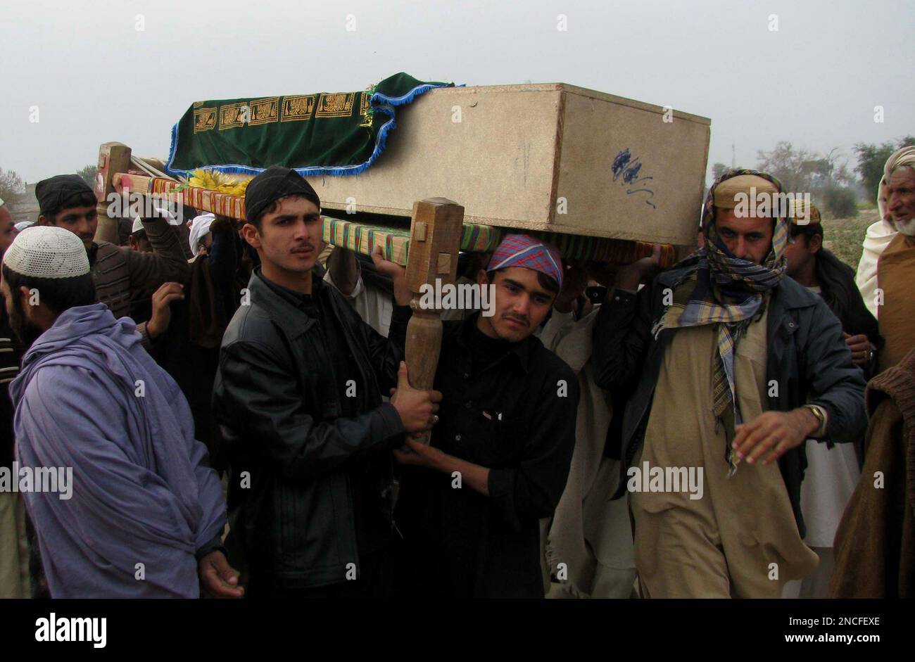 Pakistani villagers carry a dead body of a man reportedly killed by a U ...