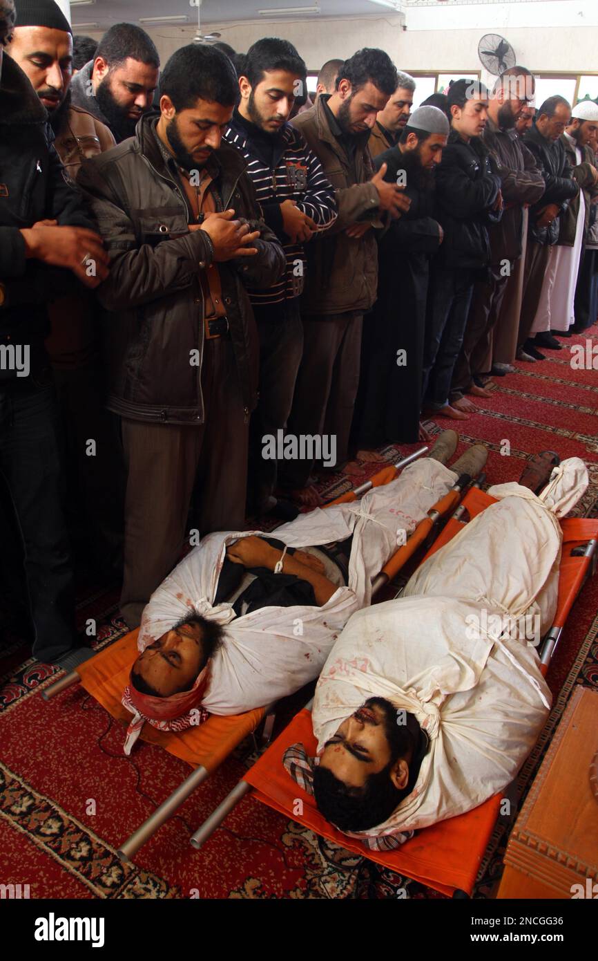 Palestinian mourners pray over the bodies of Abdullah Al Shraihy, left ...