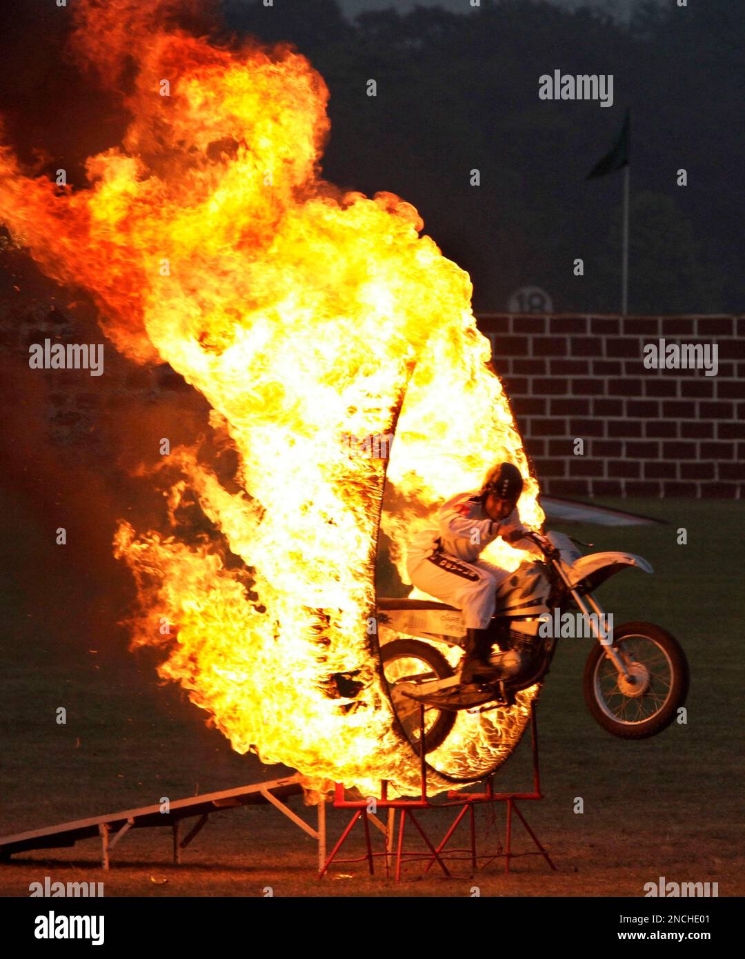 An Indian army soldier on a motorcycle jumps through a fire ring during ...