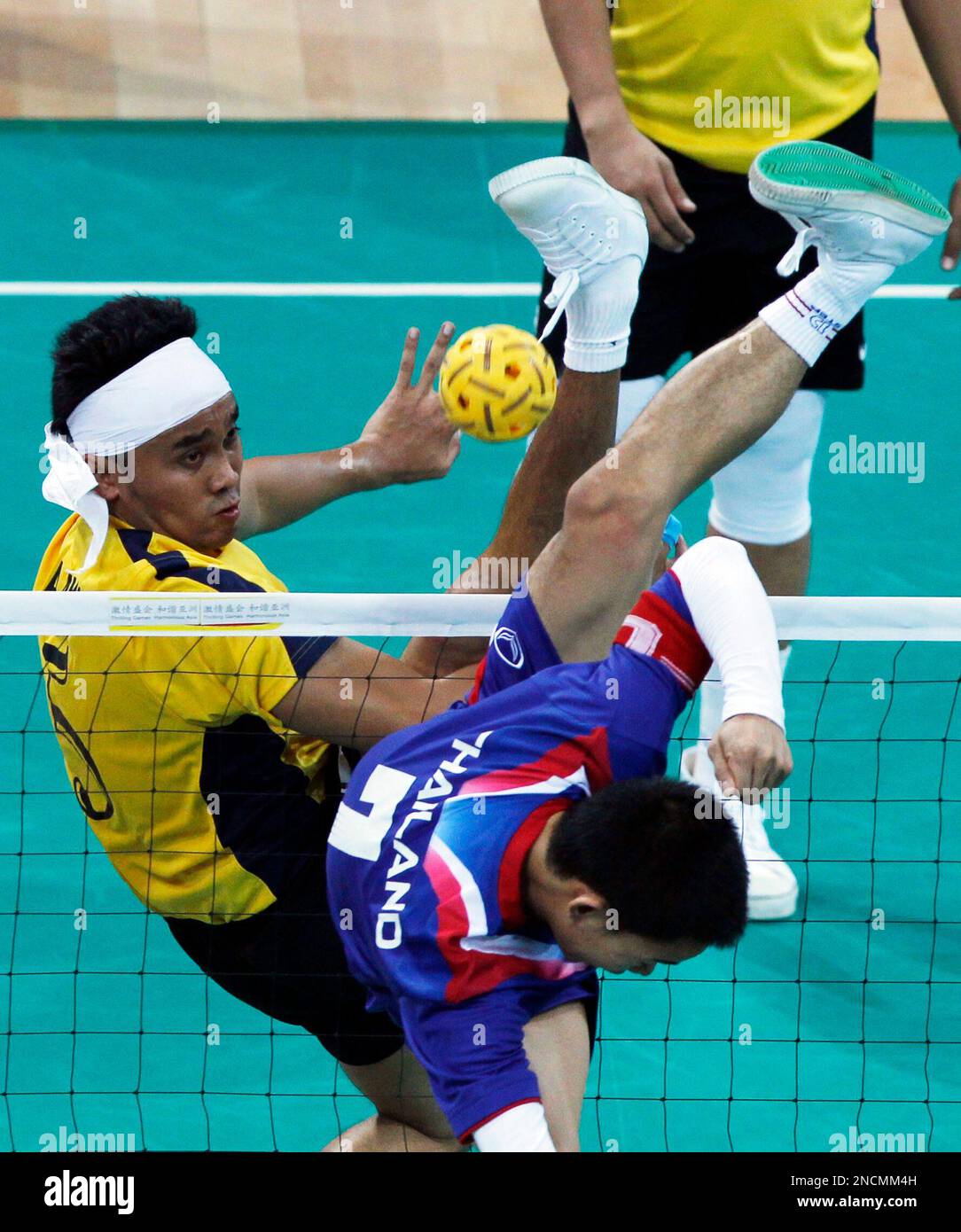 Malaysia's Mohd Futra Abd Ghani, left, kicks the ball as Thailand's ...
