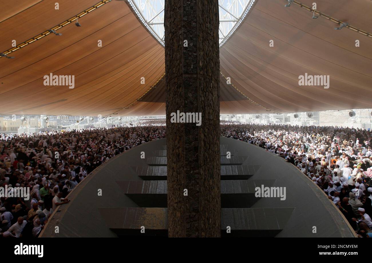 Muslim pilgrims cast stones at a pillar, symbolizing the stoning of ...