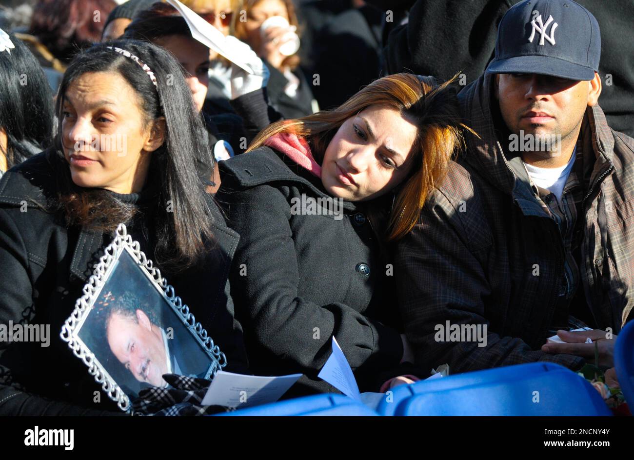 Belkis Lora, left, holds a picture of her brother Jose, as she sits ...