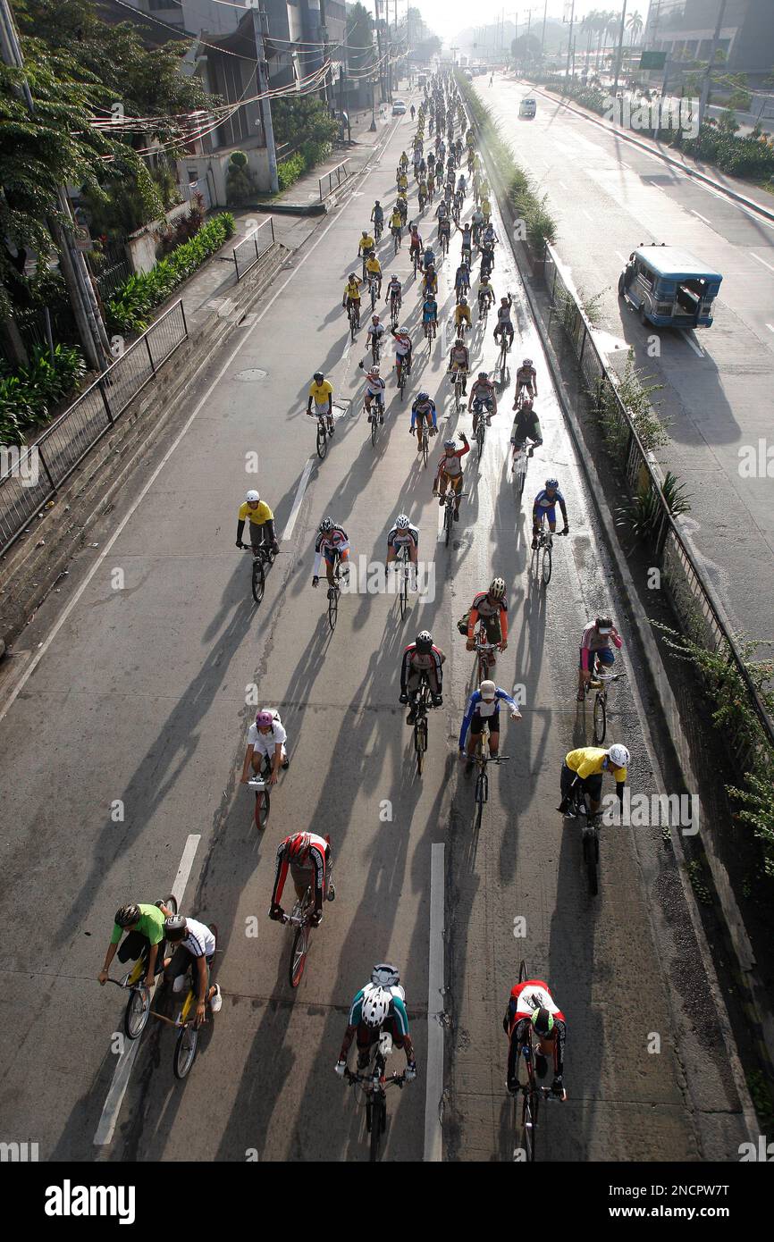 Filipino cyclists ride along a road in Quezon City, north of Manila, on ...