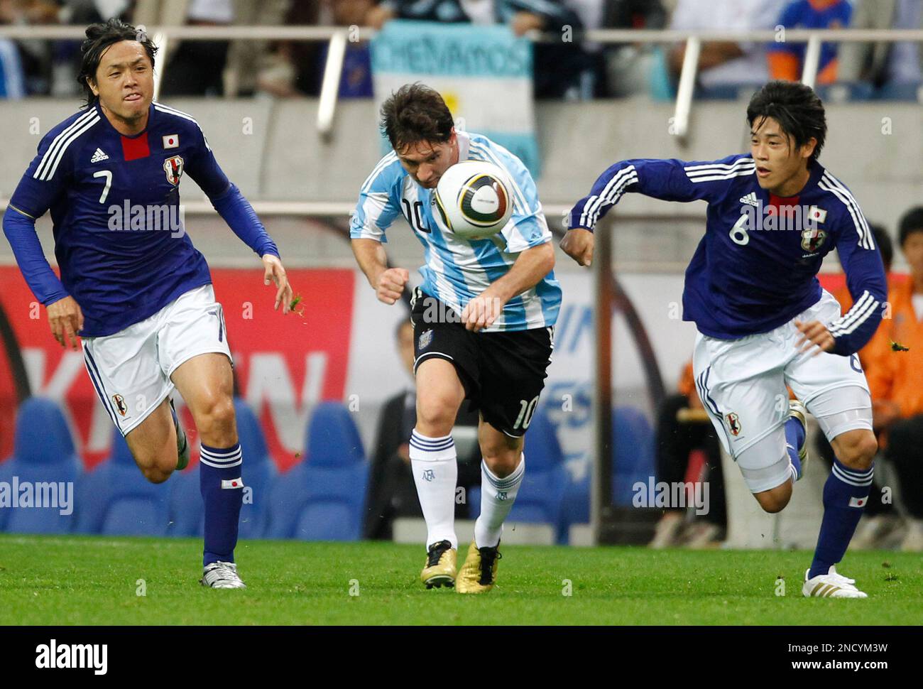 Argentina's Lionel Messi, center, makes his way between Japan's Endo ...