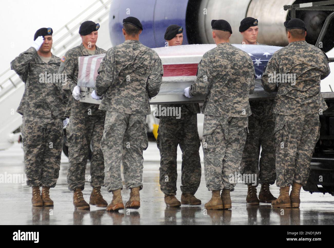 An Army carry team lifts a transfer case containing the remains of Spc ...