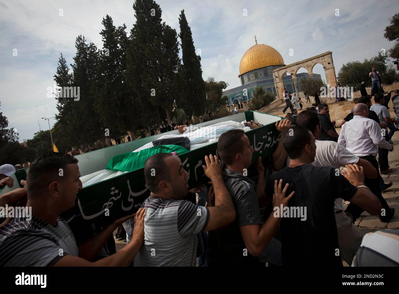 Palestinian mourners carry the coffin of Sami Sirhan during his funeral ...