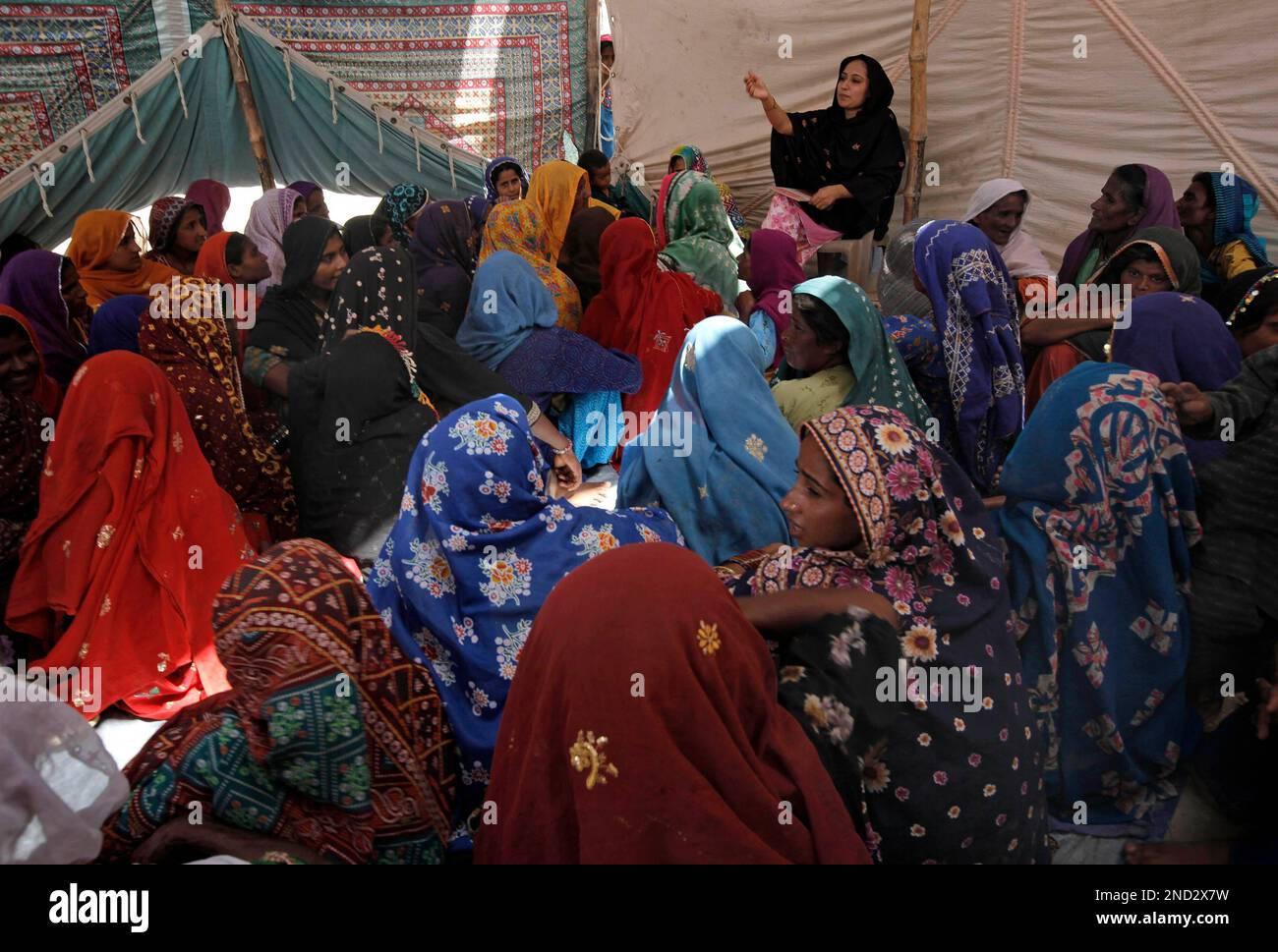 Pakistani women who survived floods take a class at a temporary ...