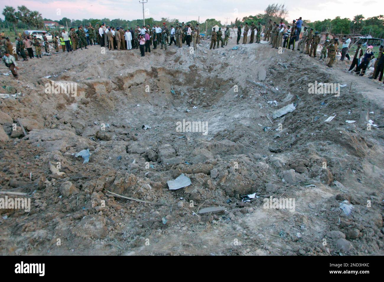 Sri Lankan police officers stand around the crater caused following an ...
