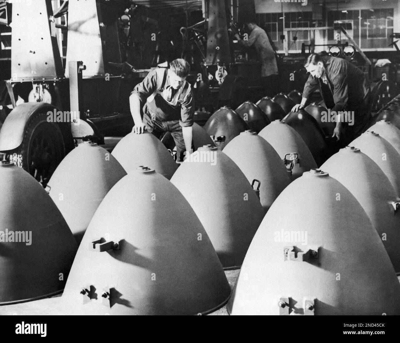 Workmen in an English factory inspecting rows of paraboloids to be used ...