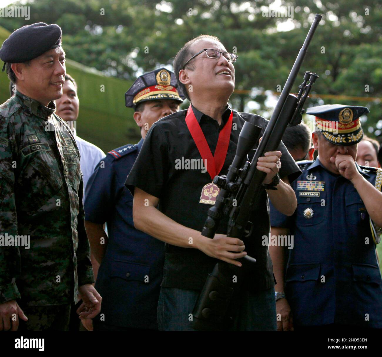Philippine President Benigno Aquino III holds a sniper's rifle during ...