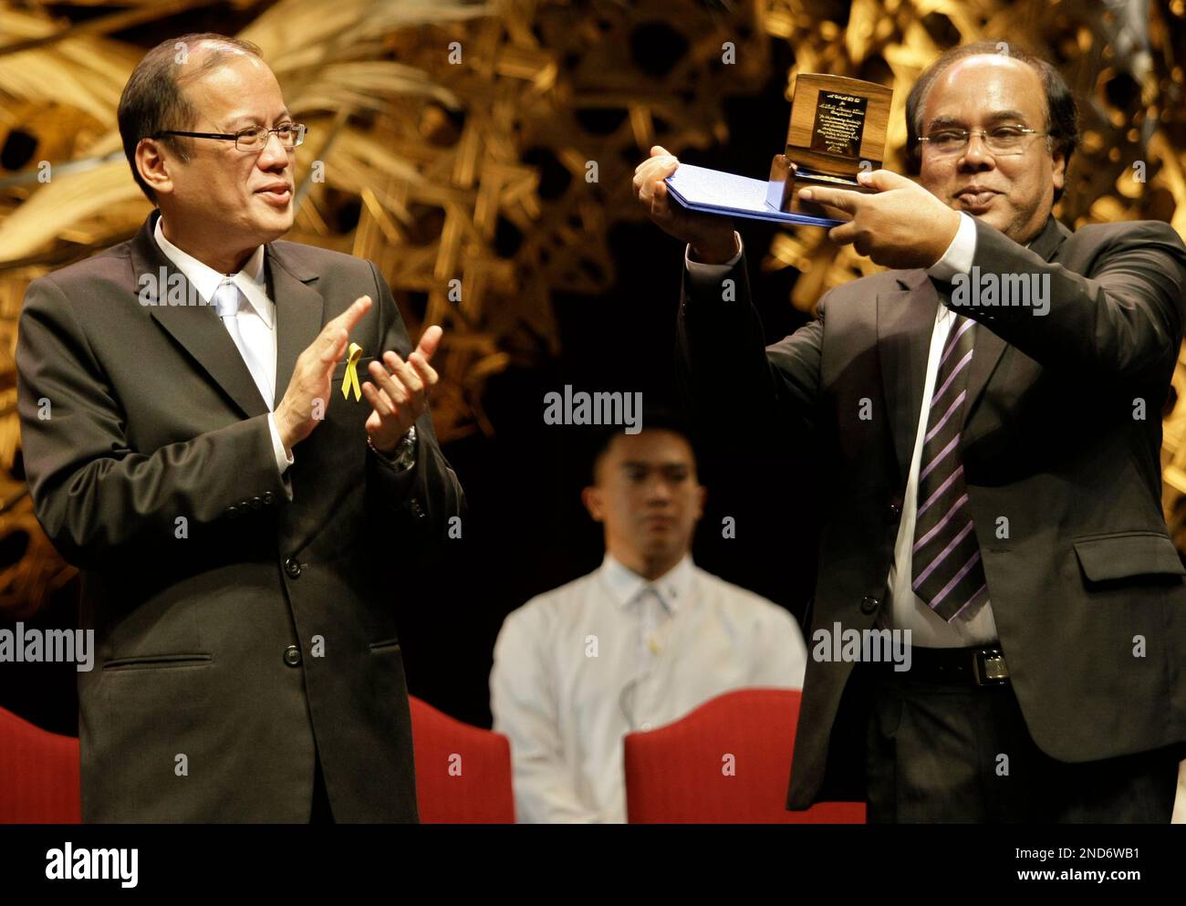 President Benigno Aquino III, left, applause as A.H.M. Noman Khan from Bangladesh shows his ...