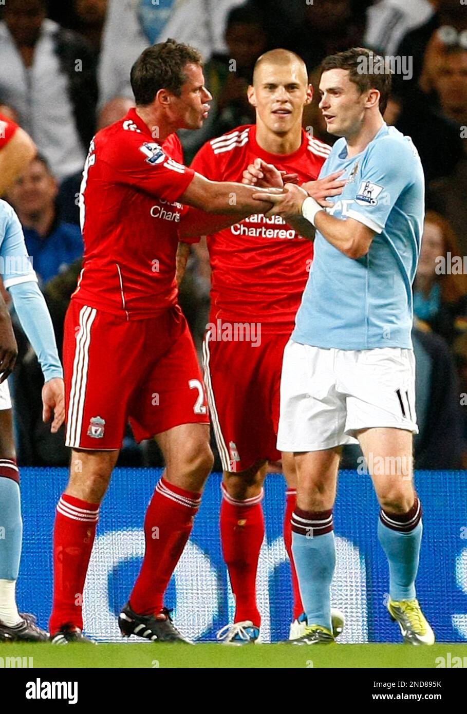 Manchester City's Adam Johnson is confronted by Liverpool's Jamie Carragher, left, after winning ...