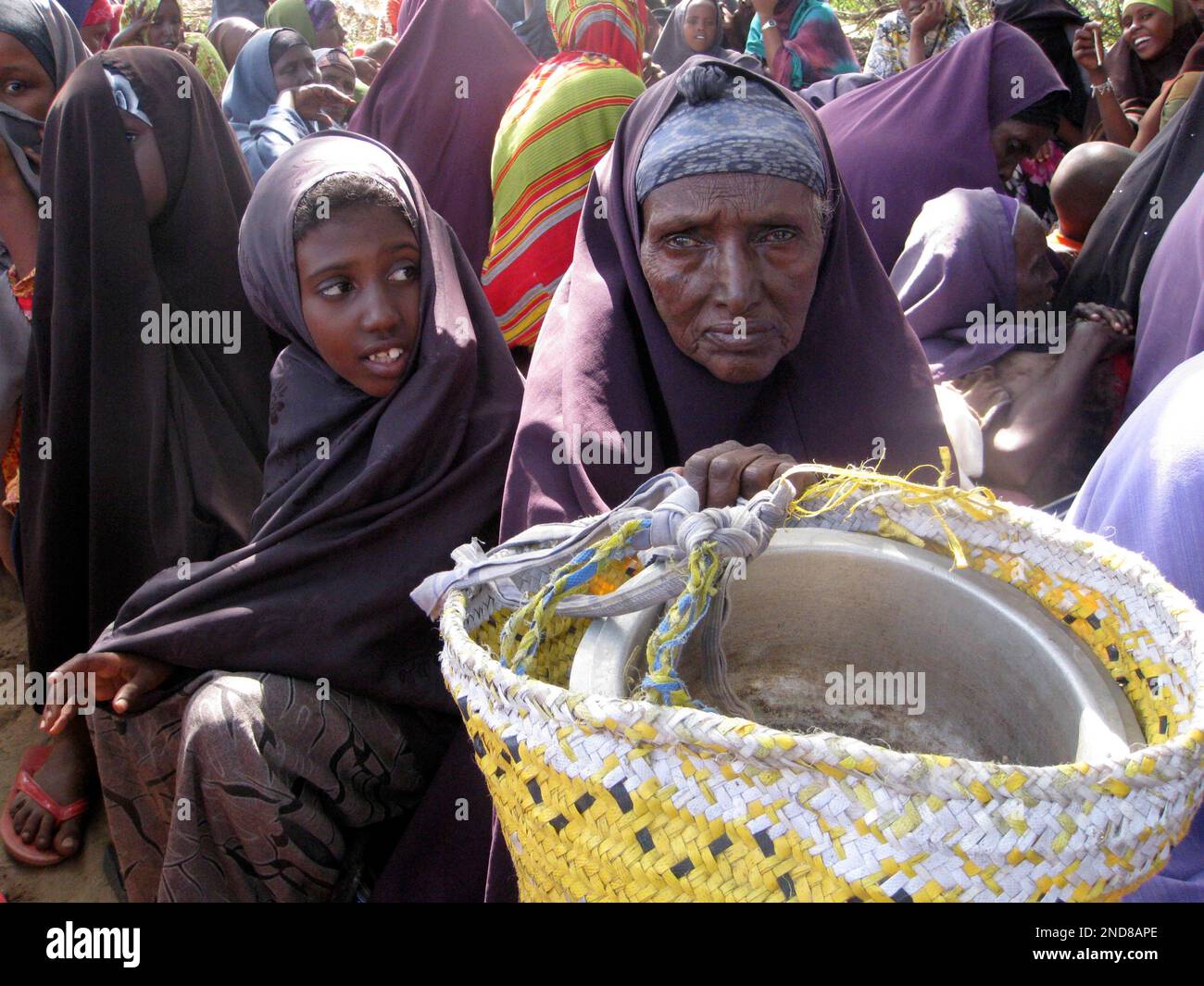 Displaced women and children wait to receive food donated by World Food ...