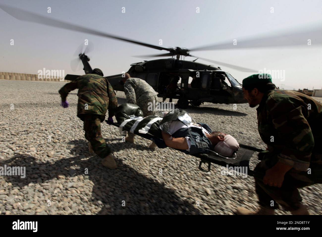 An Afghan police officer wounded in an ongoing firefight is loaded into ...