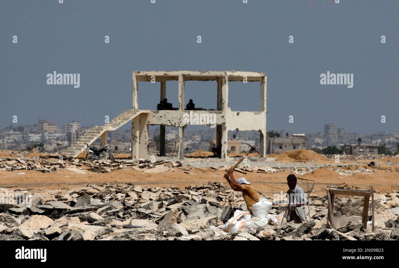 Palestinians dig through the former runway of the Gaza Strip's bombed ...