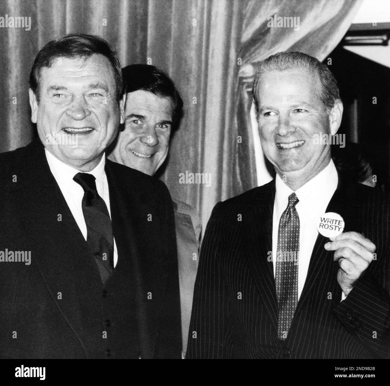 Treasury Secretary James Baker, right, shows his button which says ...