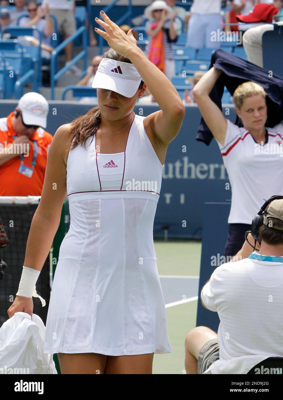 Ana Ivanovic, from Serbia, left, waves as she leaves the court after ...